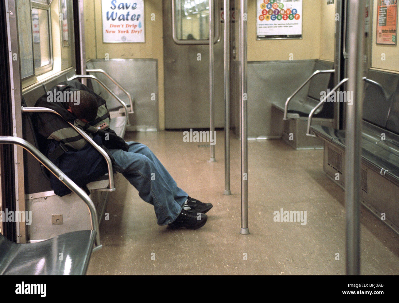Homeless man asleep on a subway on February 12, 2002. (© Frances M ...