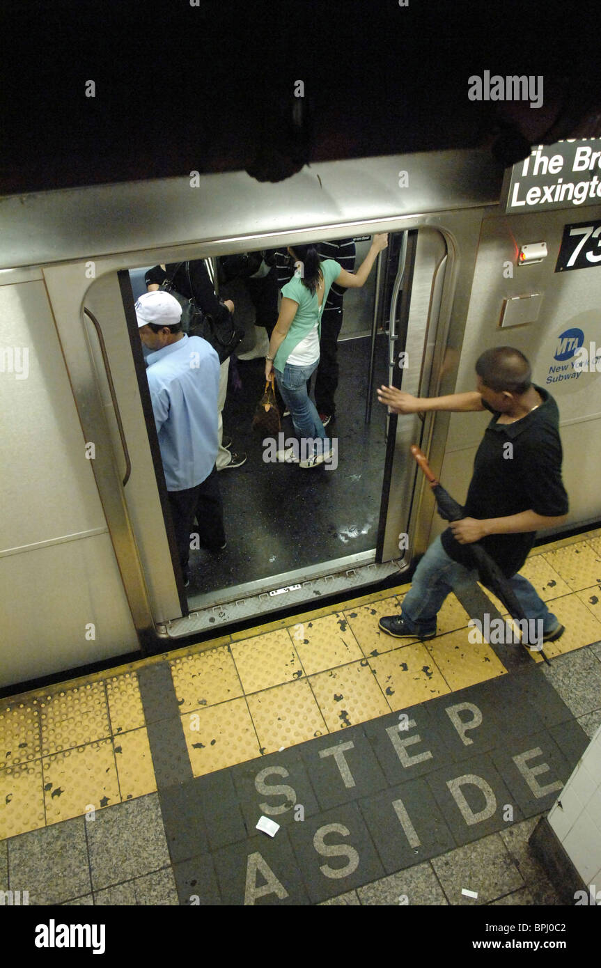 Travelers enter a subway car during their morning commute in New York ...