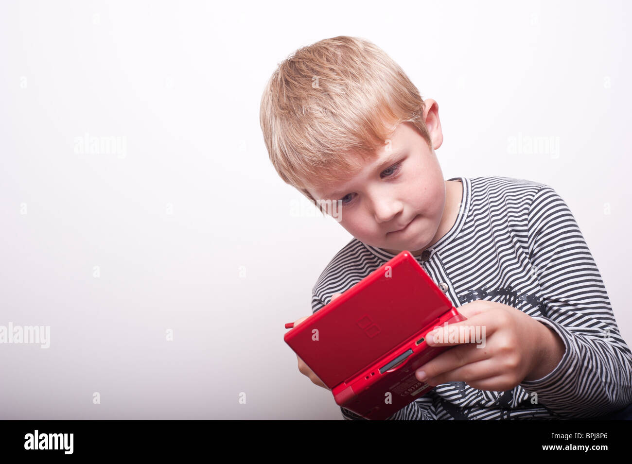 A MODEL RELEASED picture of a 6 year old boy playing with a Nintendo DS ...