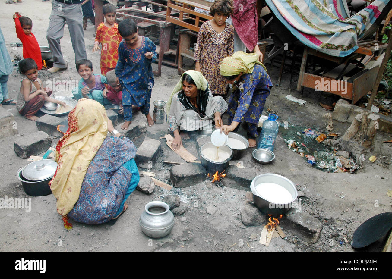 Flood affected people cook food with the help of bushes at flood ...