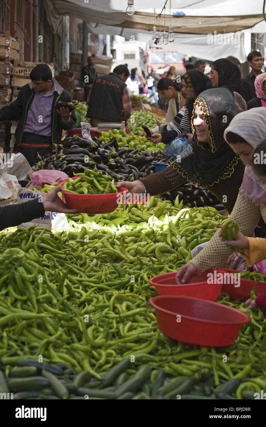vegetable stall at a market in Tarlabasi, traditionally dressed women ...