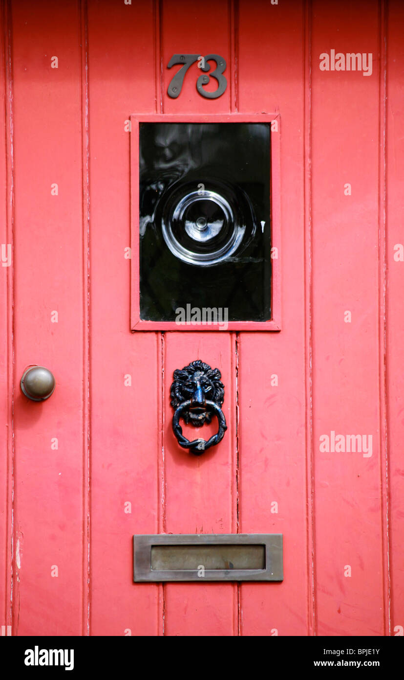Red door with a number, letterbox and door knocker Stock Photo - Alamy