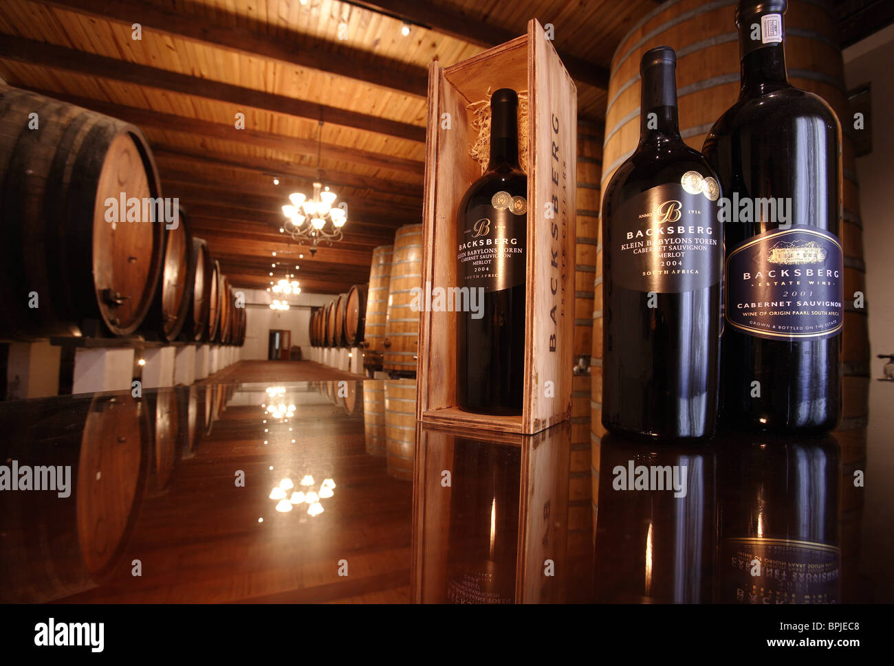 Wine cellar with wine barrels and wine bottles, Backsberg estate, Paarl ...