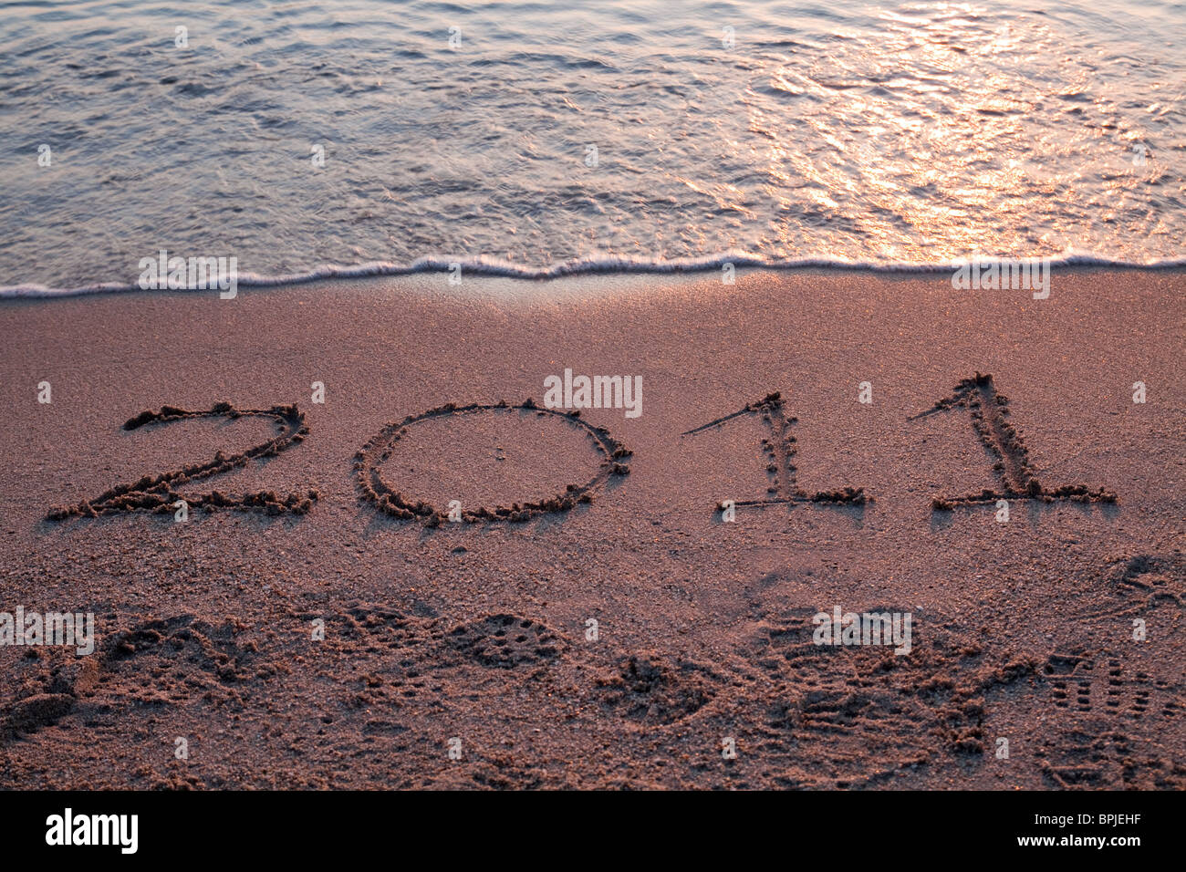 Year 2011 date written on the sand of a beach Stock Photo - Alamy