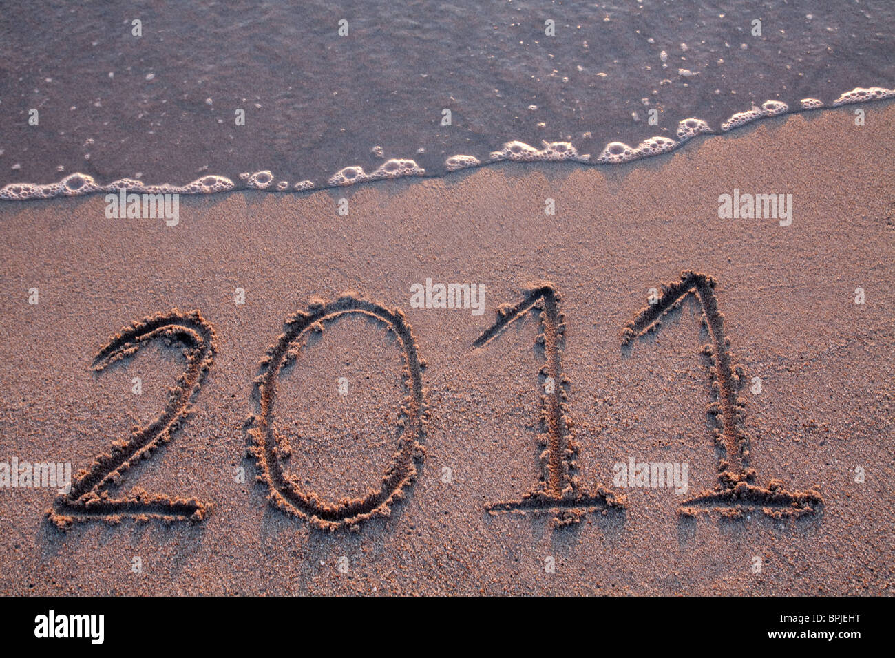 Year 2011 date written on the sand of a beach Stock Photo - Alamy