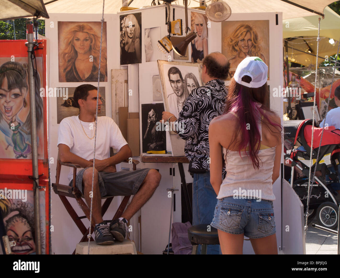 Man sitting for portrait artist while woman watches. Montreal, Canada ...