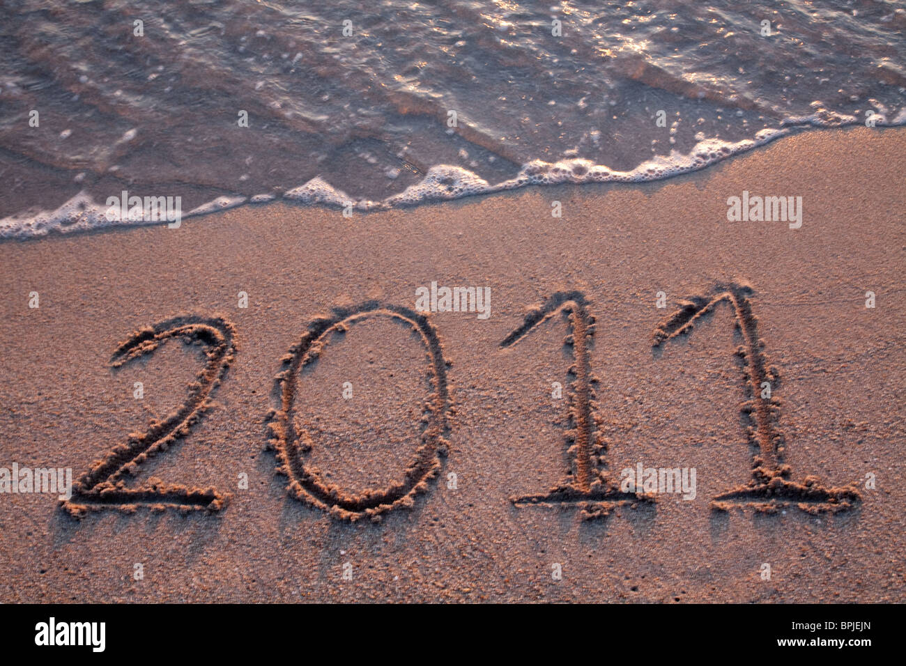 Year 2011 date written on the sand of a beach Stock Photo - Alamy