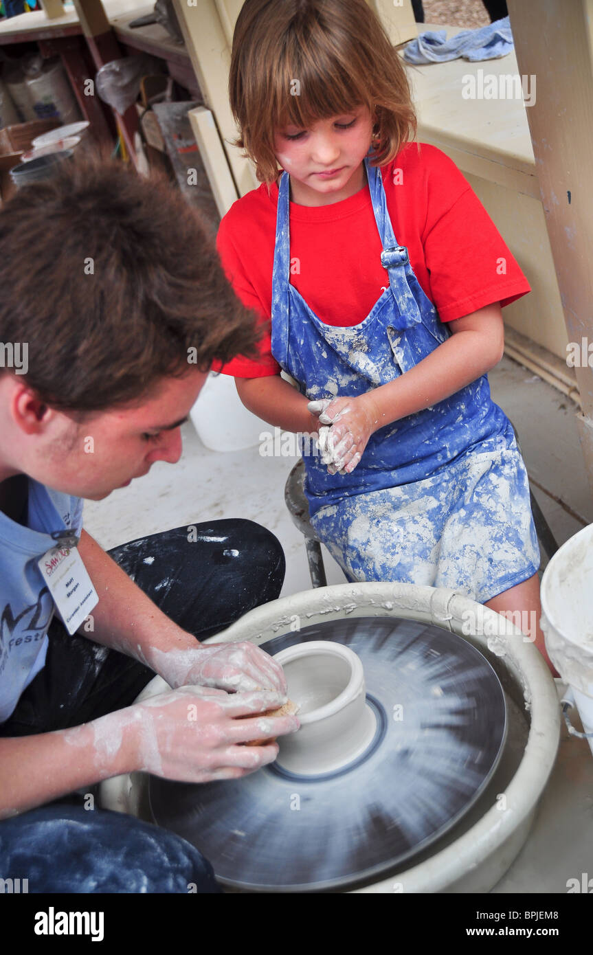 Teen boy teaches young girl how to make a ceramic pot Stock Photo - Alamy