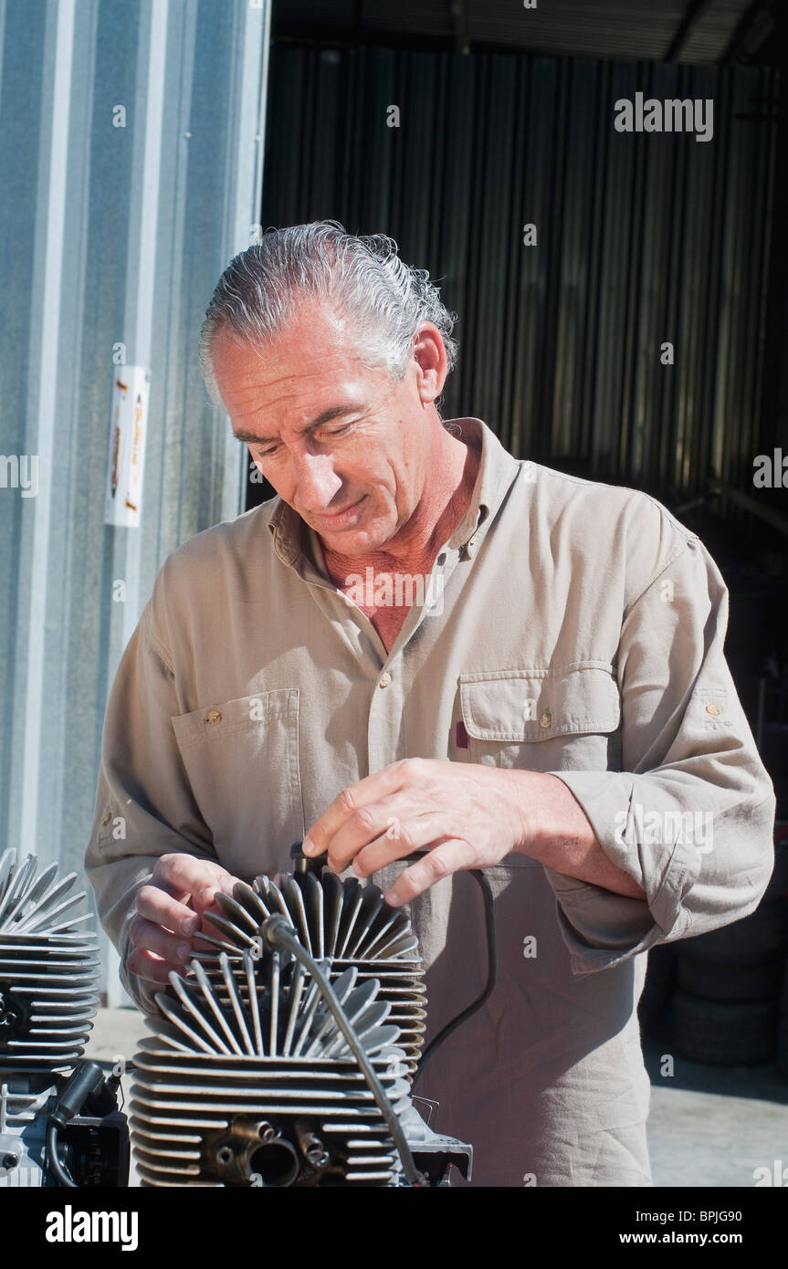 Hispanic mechanic working on engine Stock Photo - Alamy