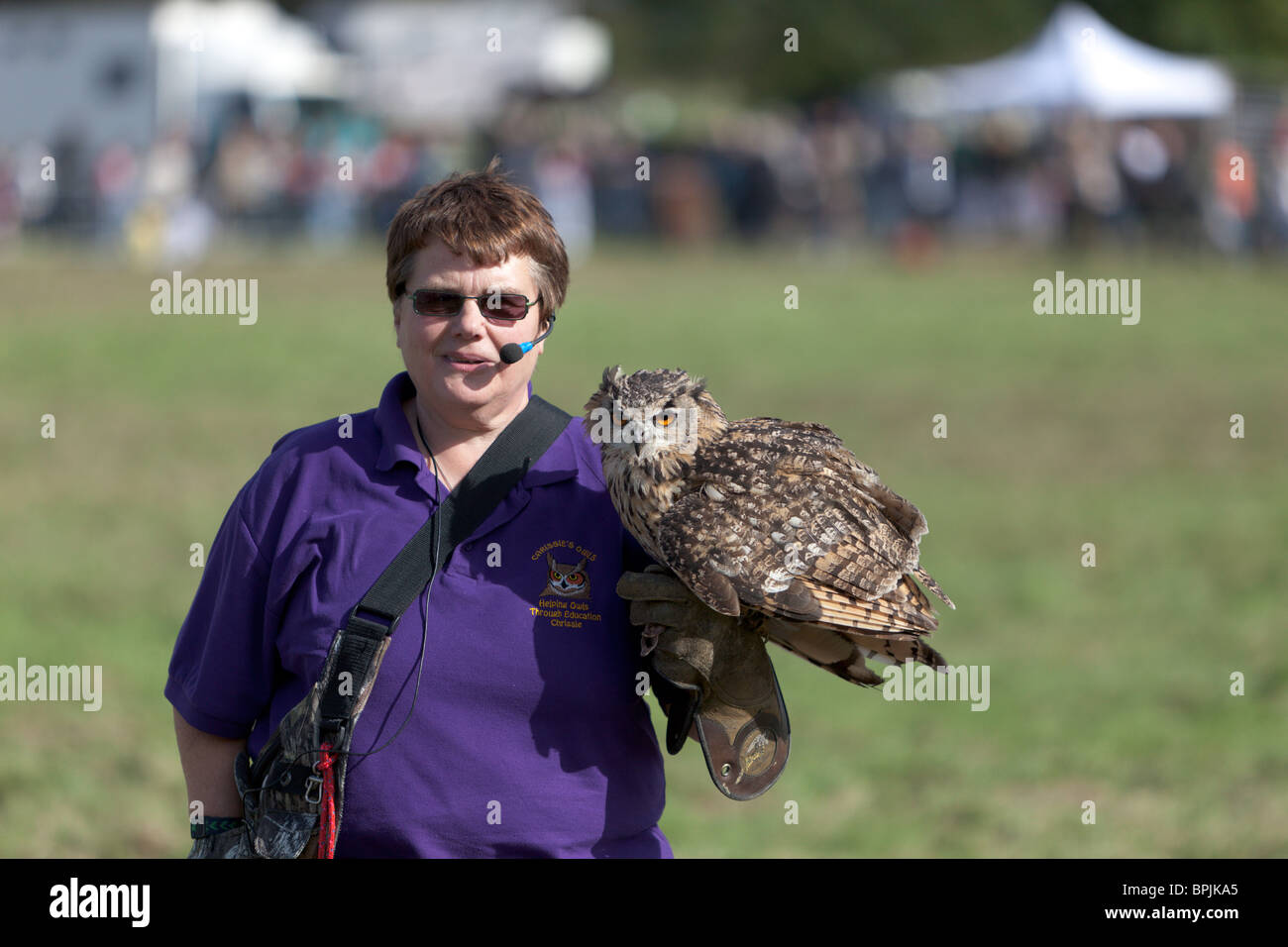 a Bird handler with a large owl at a public show Stock Photo - Alamy