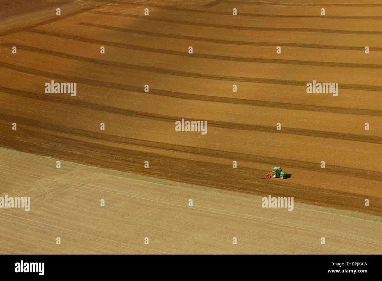 Aerial view of a tractor ploughing in summertime, Lorraine region ...