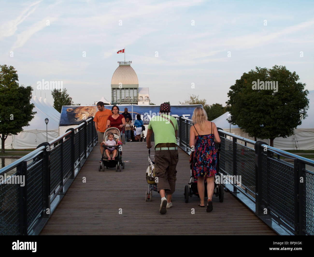 Couples with strollers on pedestrian bridge. Montreal riverfront ...
