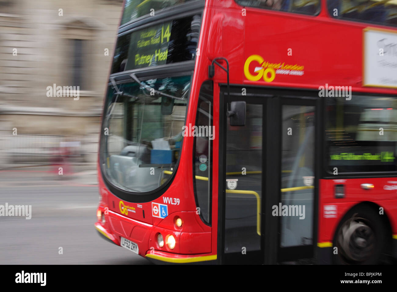 A double decker bus driving through London Stock Photo - Alamy