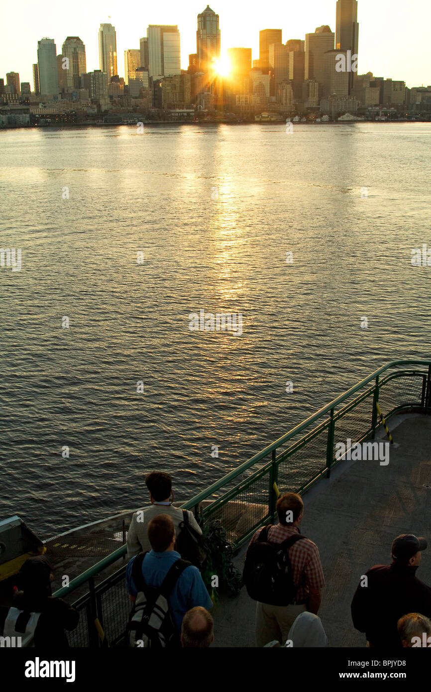 Morning ferry arriving to Seattle waterfront with skyline and sunrise ...