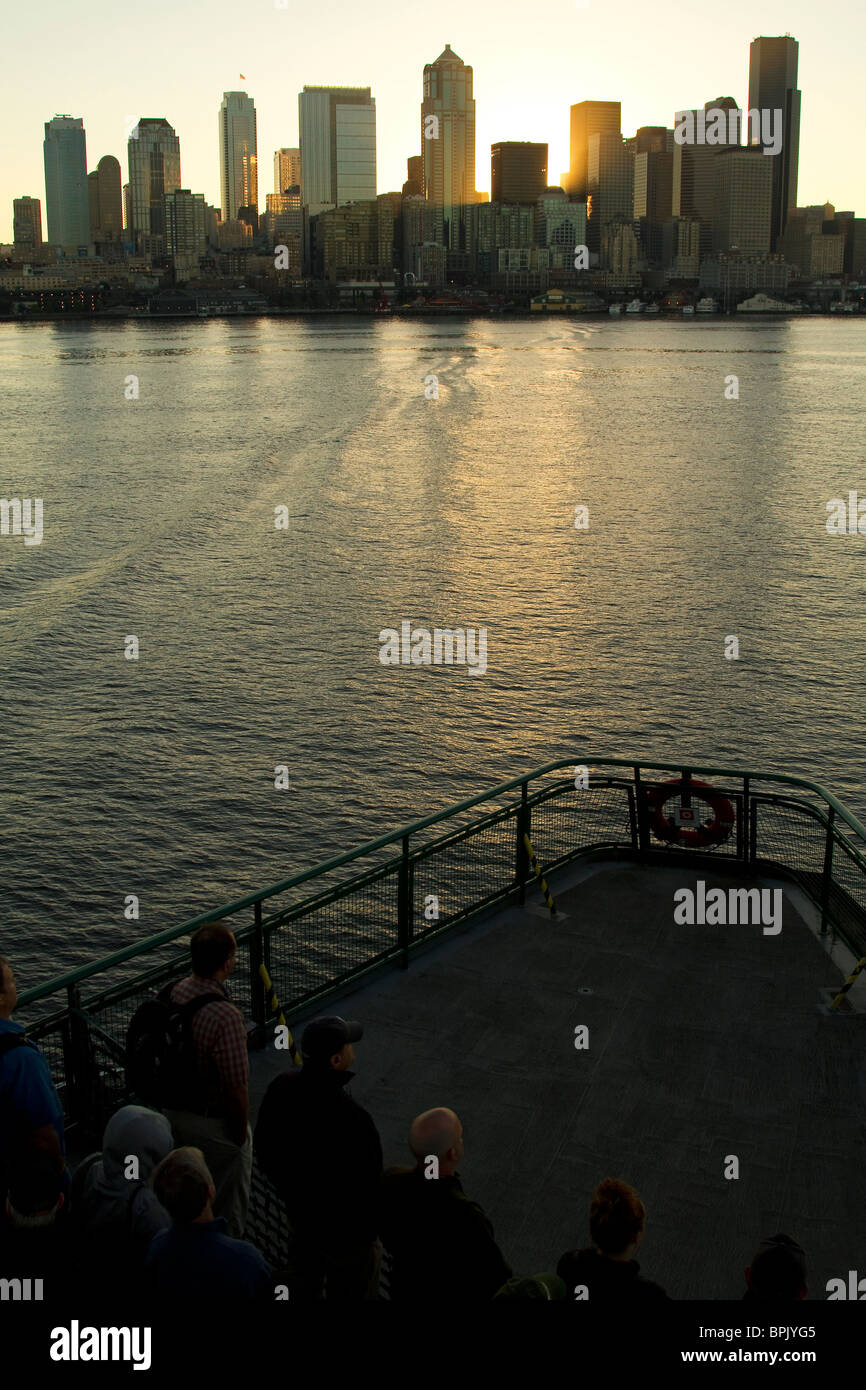 Morning ferry arriving to Seattle waterfront with skyline and sunrise ...