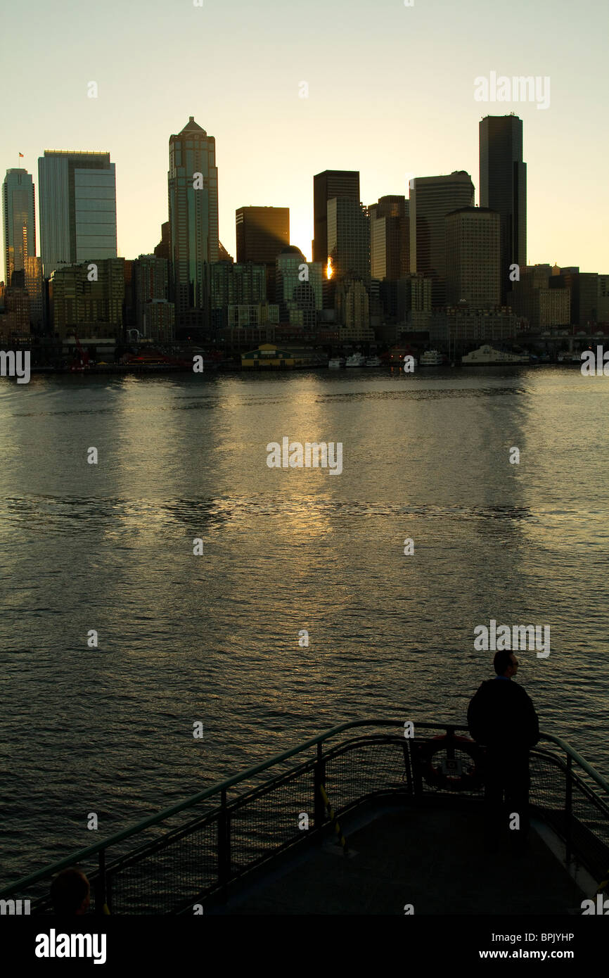 Morning ferry arriving to Seattle waterfront with skyline and sunrise ...
