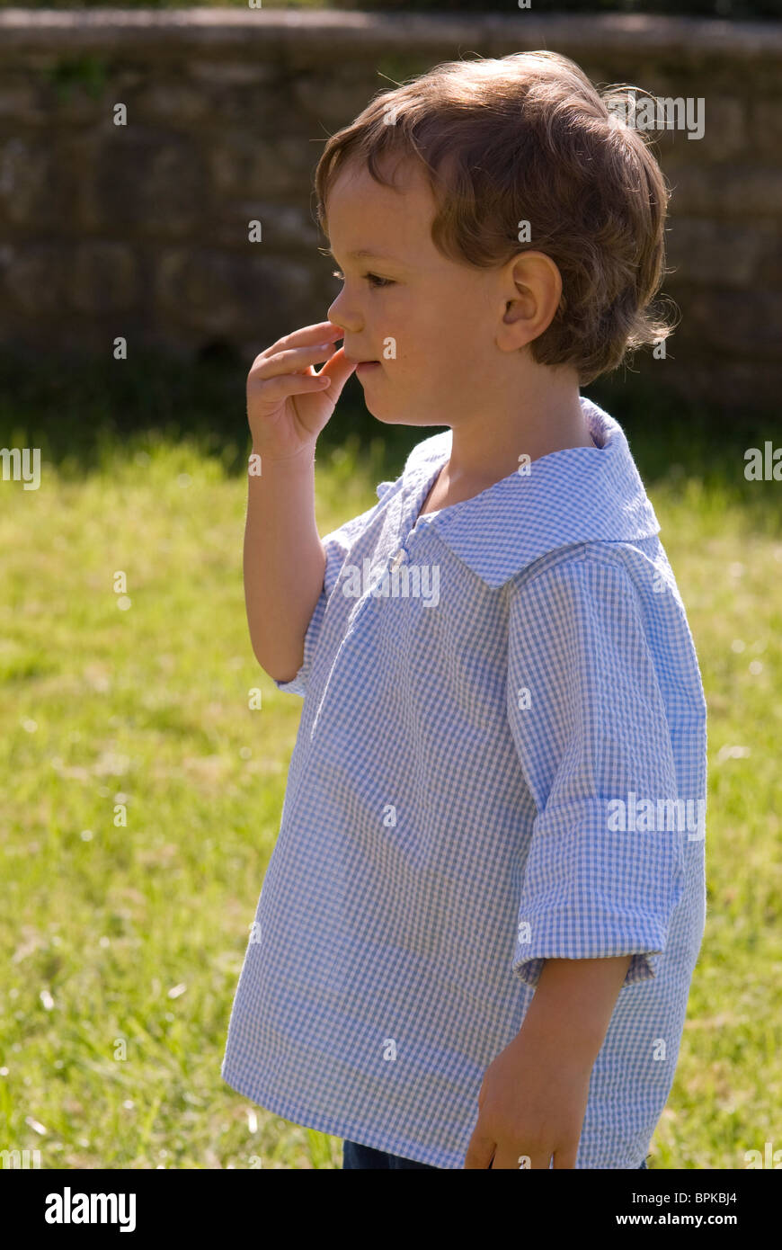 Side view of a little boy wearing a blue shirt Stock Photo - Alamy