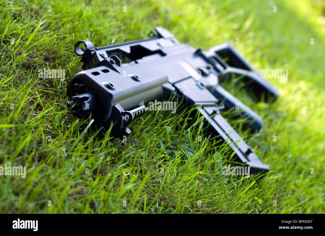 Airsoft automatic rifle in the grass Stock Photo - Alamy