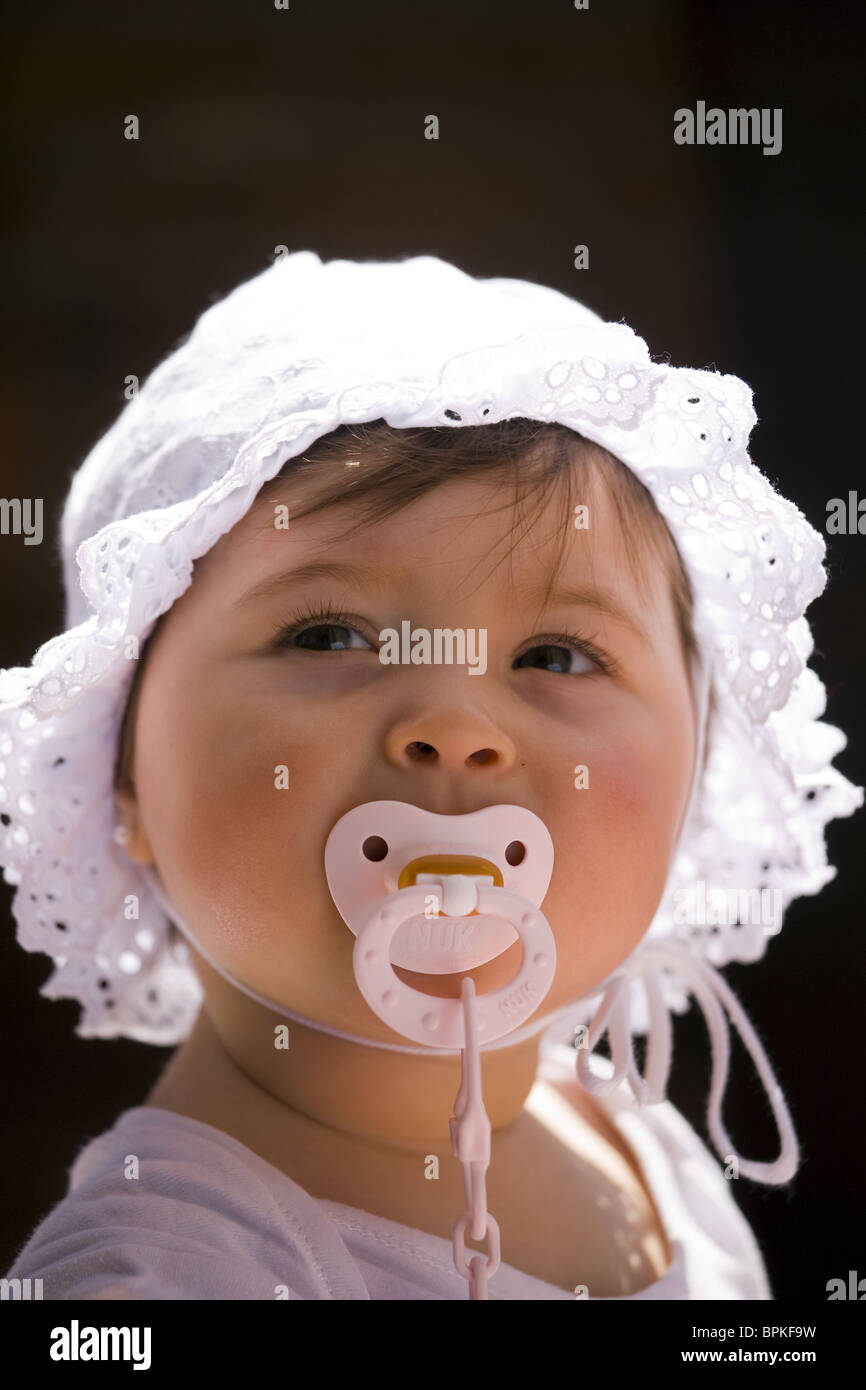 Baby girl with pacifier looking front Stock Photo - Alamy
