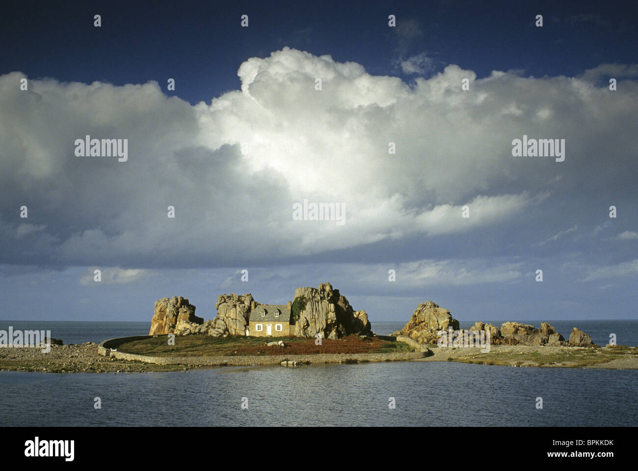 Lonely house between rocks under clouded sky, Pointe de Chateau ...