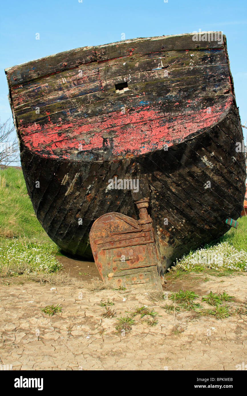 The rotting stern of an old fishing boat with its rusty rudder and ...