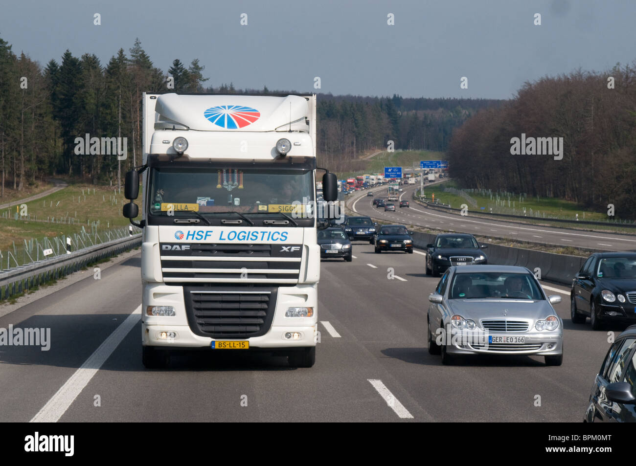 A DAF truck from Holland leads a long line of lorries up a hill on a ...