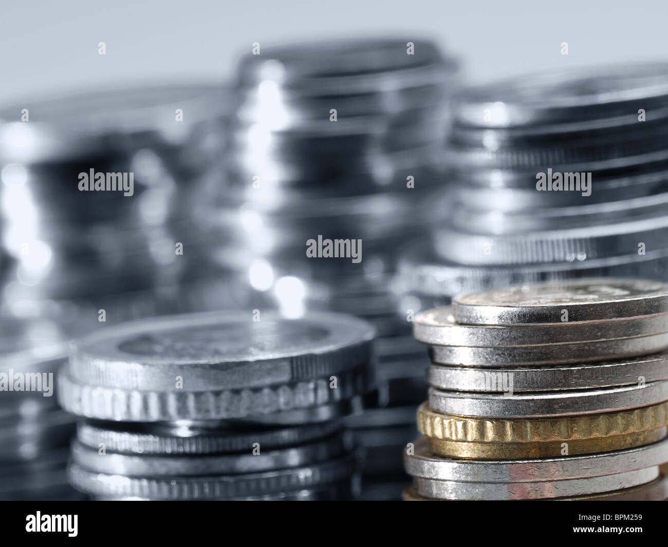 stacks of money coins , blue toned closeup photo with shallow DOF ...
