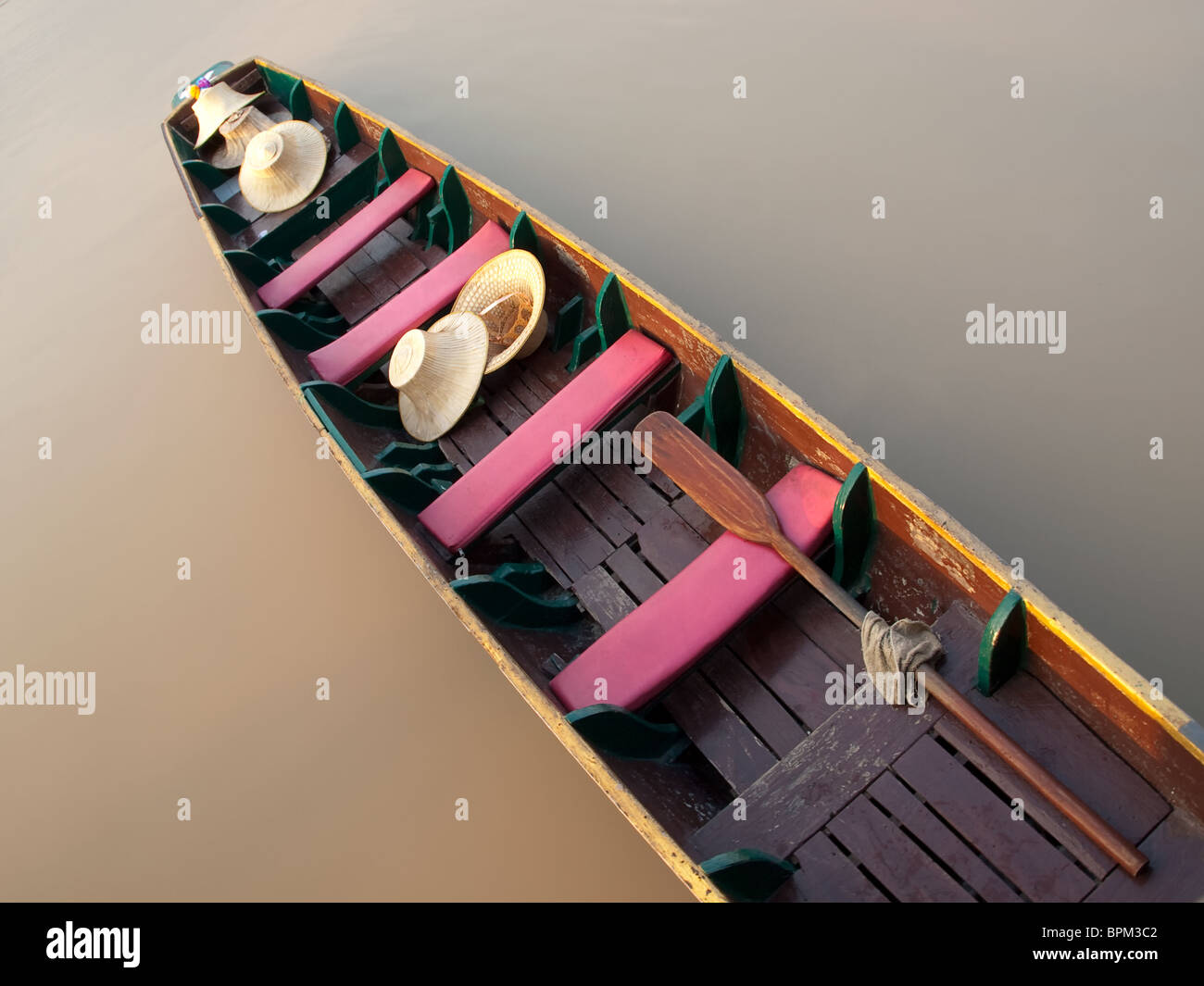 Empty boat floating on the calm river with only hats on it , closeup ...