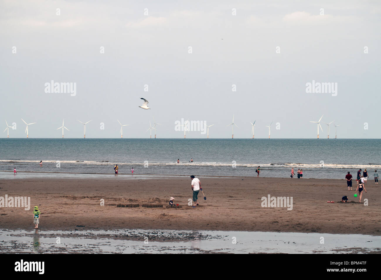 Beach scene with wind turbines in a wind farm on the Coast of Skegness ...
