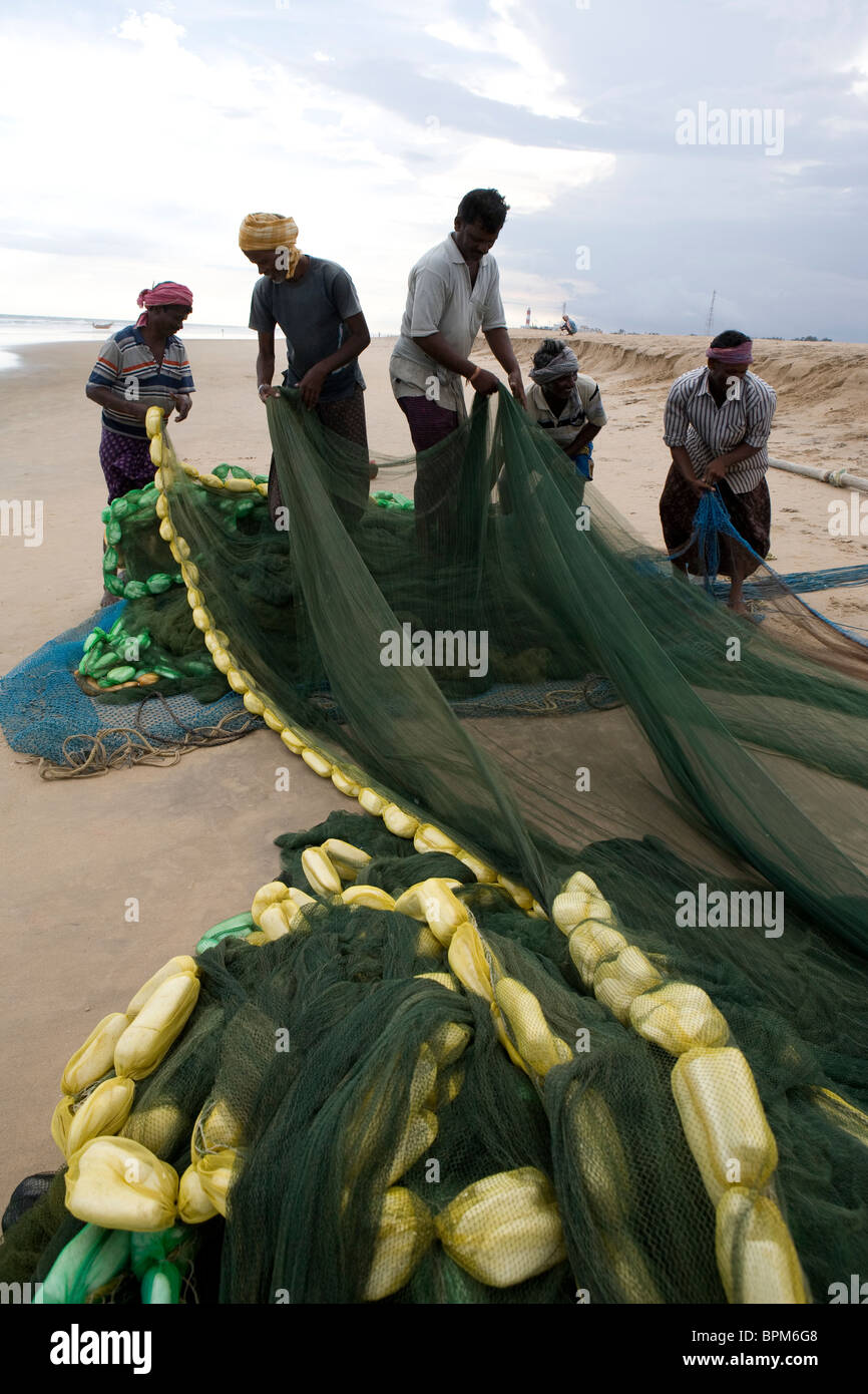 Fishermen are preparing nets for the next day on the beach near the ...