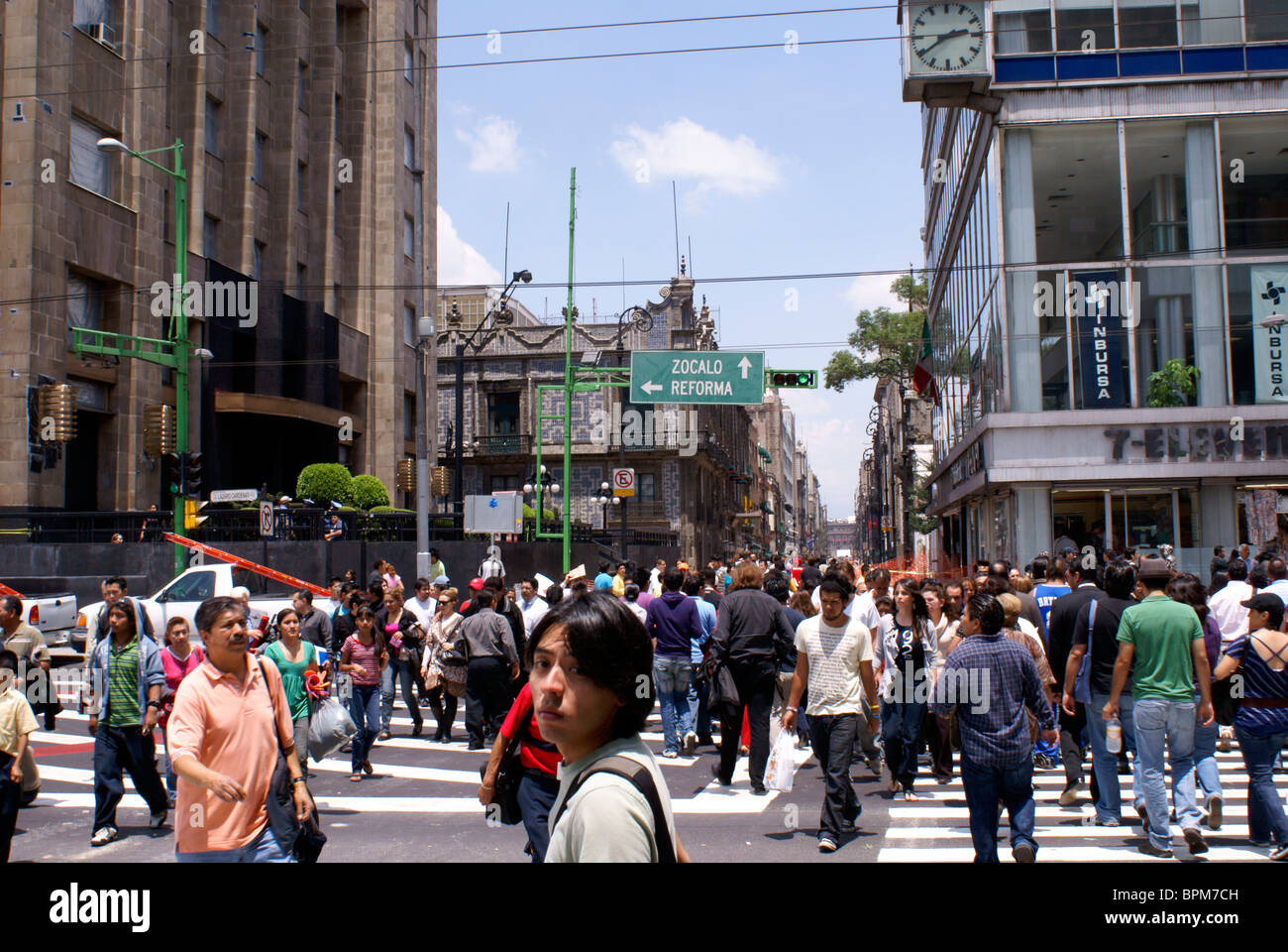 Crowds of pedestrians crossing a busy intersection in downtown Mexico ...