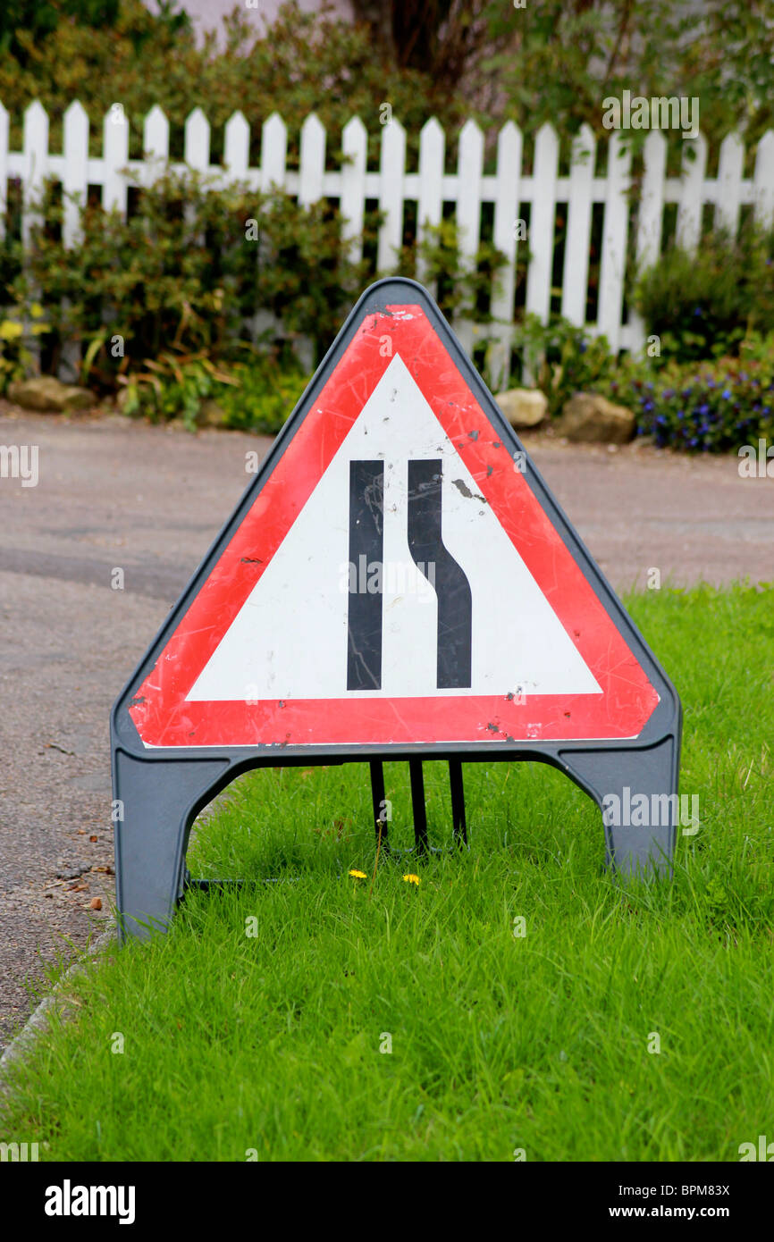 Road narrows temporary sign on the verge of a country lane with a ...