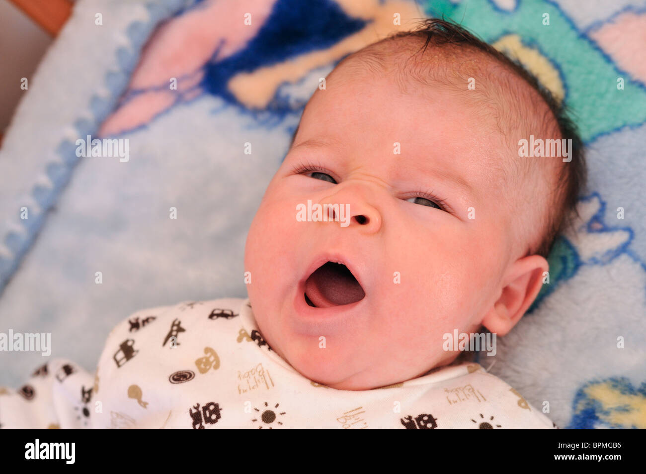 One and half months old baby yawning in his bed Stock Photo - Alamy