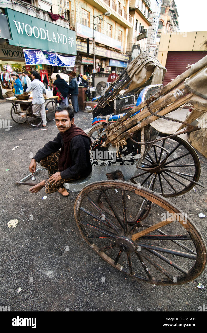 A Rickshaw puller resting by his rickshaw in the old streets of ...