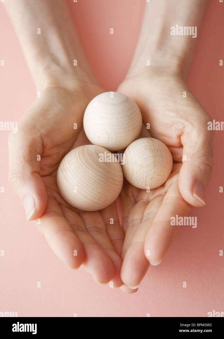 Hands holding small wooden balls hi-res stock photography and images ...