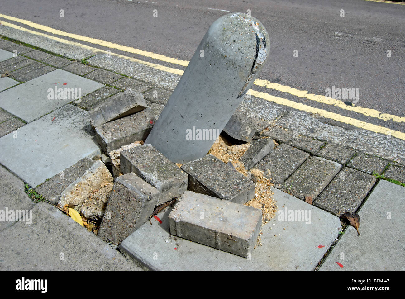 uprooted concrete bollard and disturbed bricks on pavement Stock Photo ...