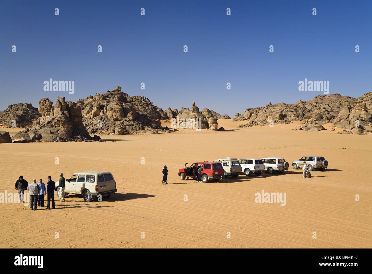 Jeeps and tourists in stony desert, Akakus mountains, Libya, Sahara ...