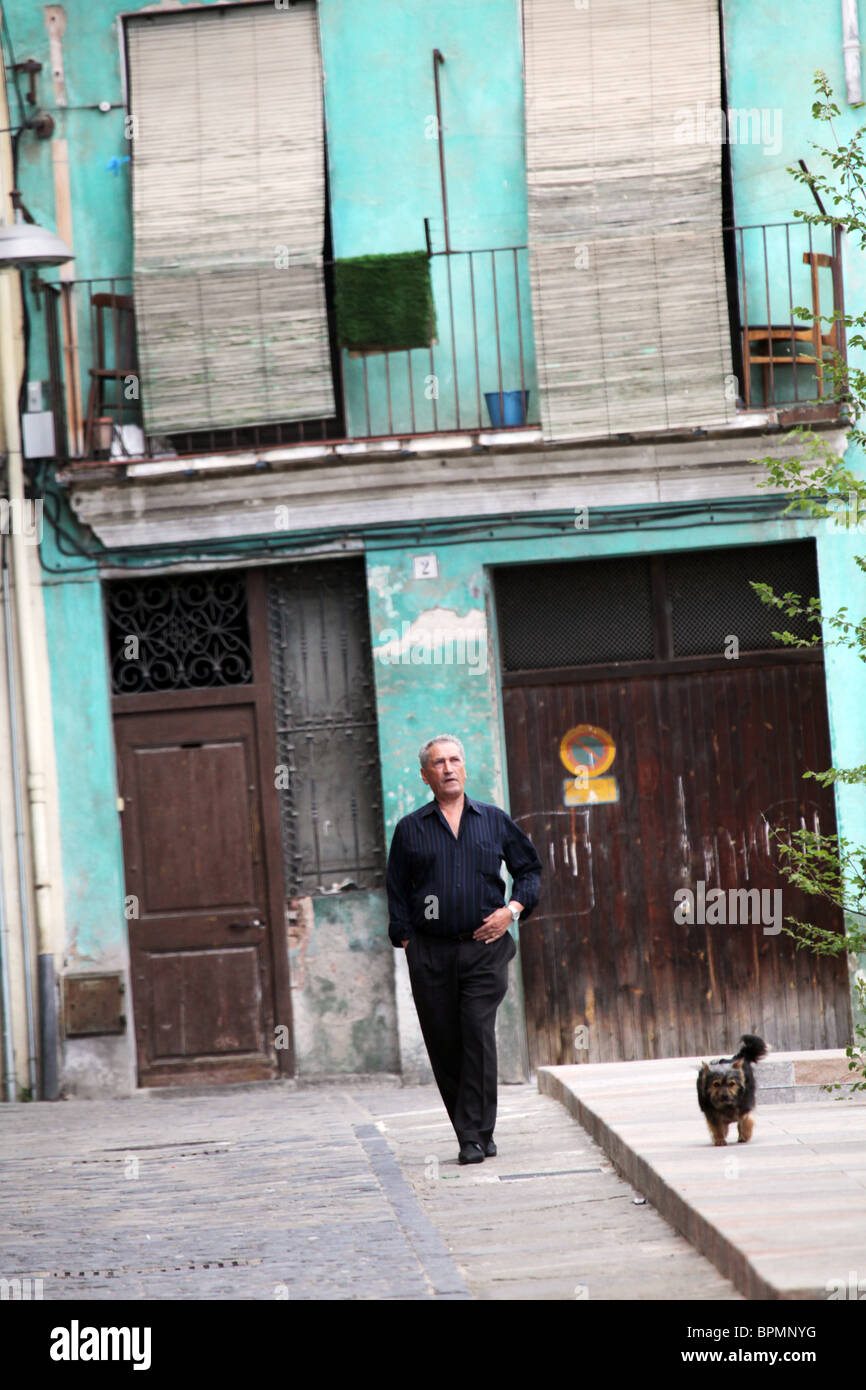 Man walking dog – A block of poor houses and flats street scene from ...