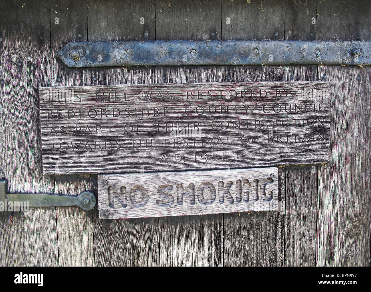 A wooden sign noting the restoration of Stevington Mill in Bedfordshire ...