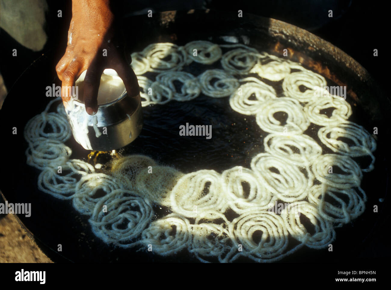 Cooking pastries at a street stall in Una, Saurashtra, Gujarat, India ...