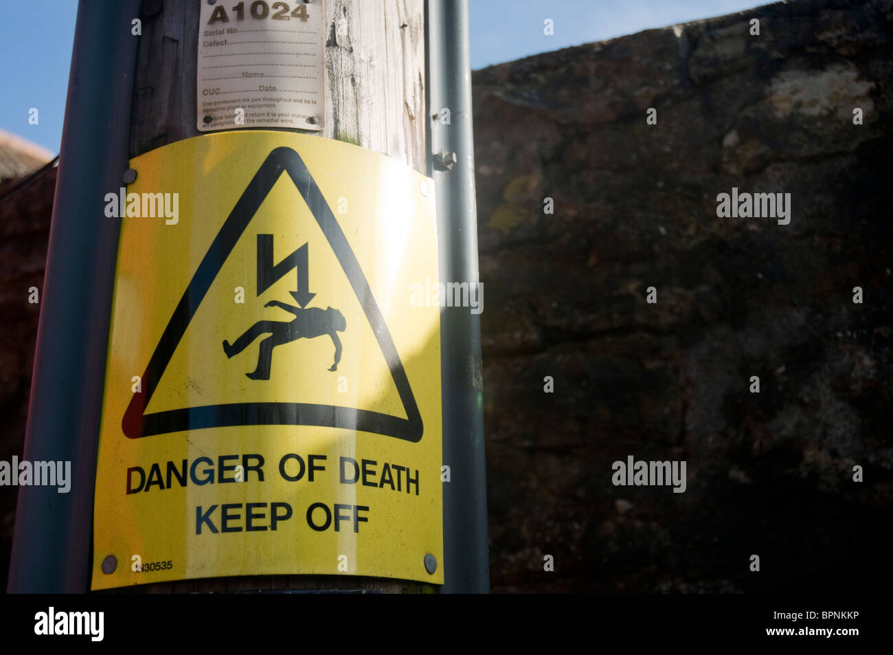 An electricity pole warning sign Stock Photo - Alamy