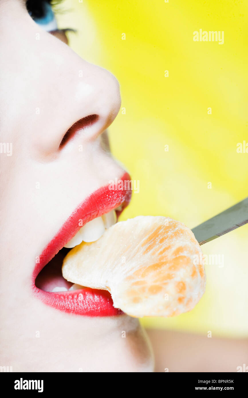 beautiful caucasian woman portrait eating a tangerine slice studio on ...