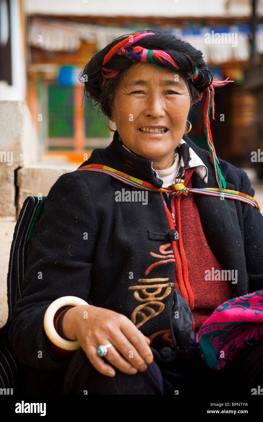 A lady dressed in traditional minority clothes rests near songzanlin ...