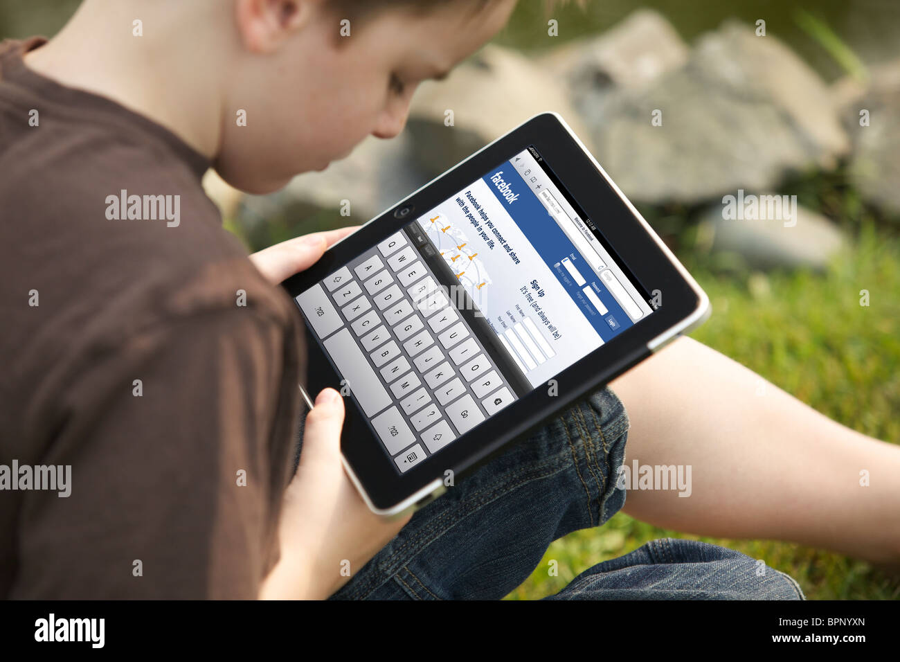 Young boy using an iPad to open Facebook page Stock Photo - Alamy
