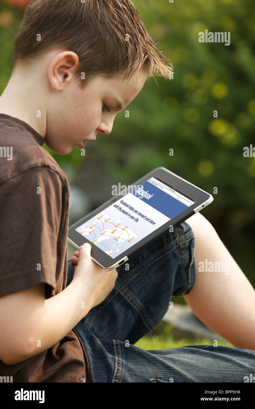 Young boy using an iPad to check his Facebook account Stock Photo - Alamy