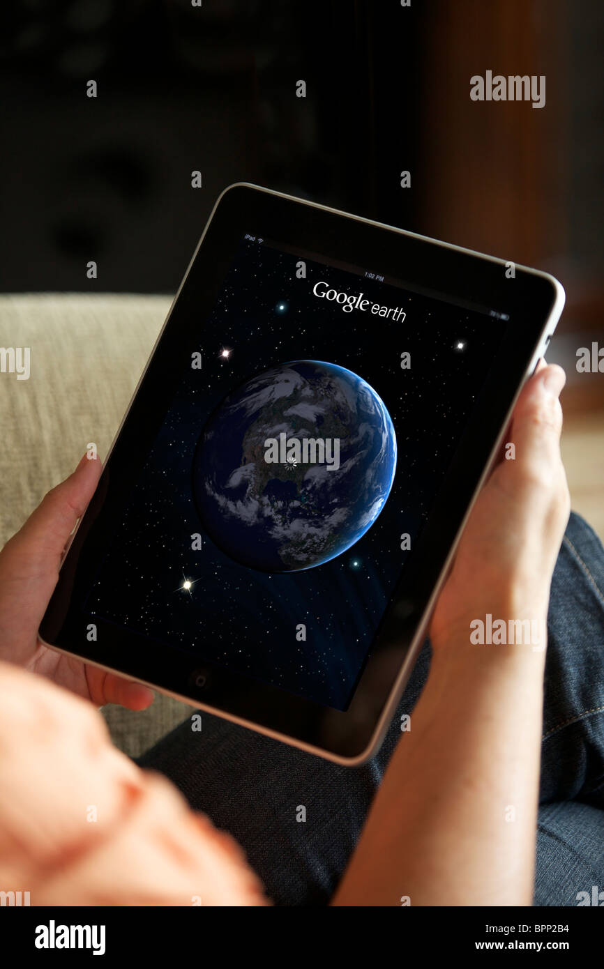Close up of a woman handholding an iPad showing Google Earth ...