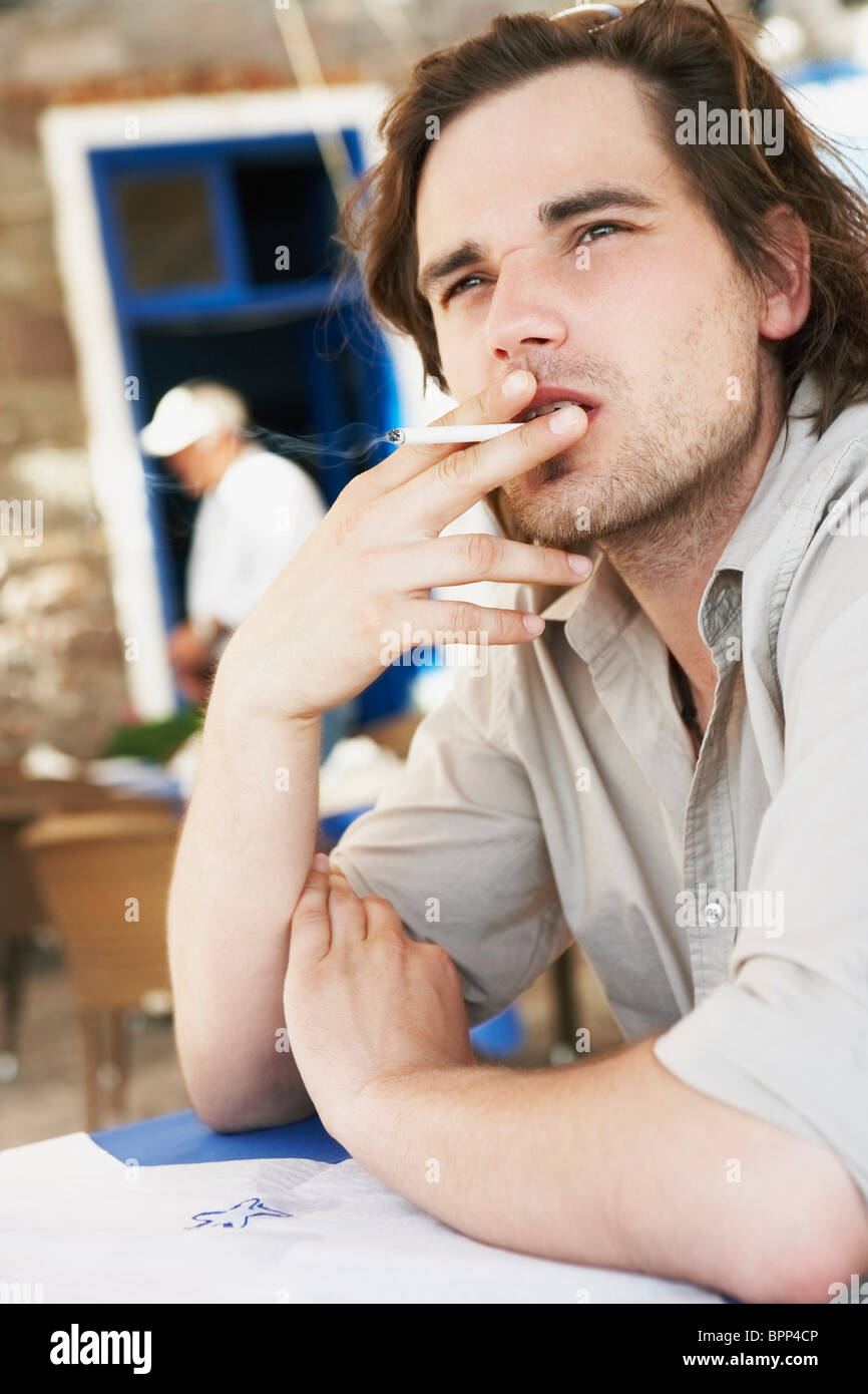 Man smoking cigaret in restaurant Stock Photo - Alamy