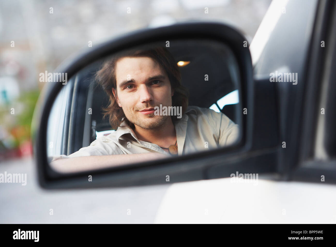 Man looking at driving mirror Stock Photo - Alamy