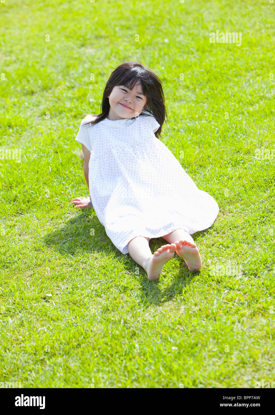 Girl sitting on grass Stock Photo - Alamy