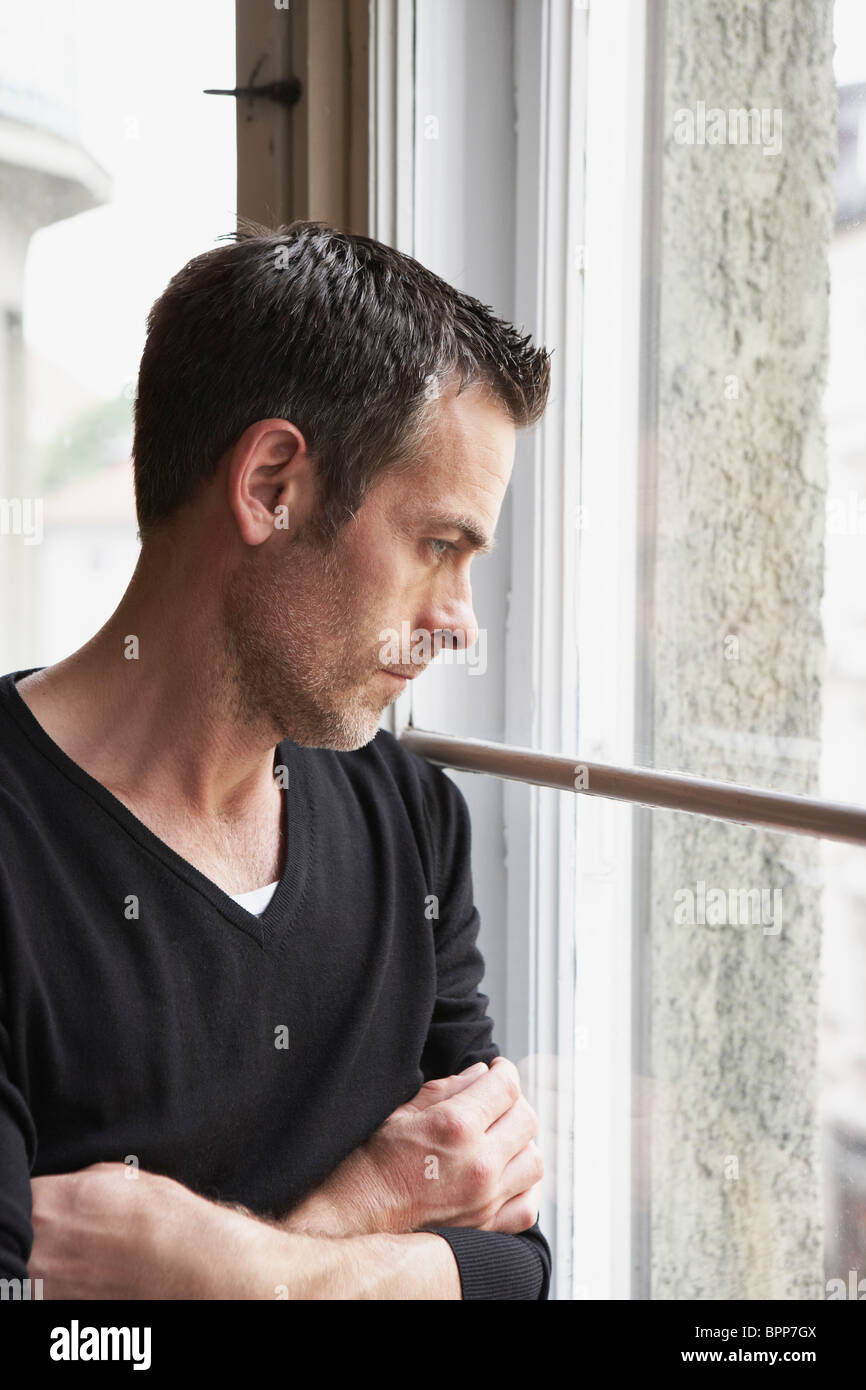 Man looking out window Stock Photo - Alamy